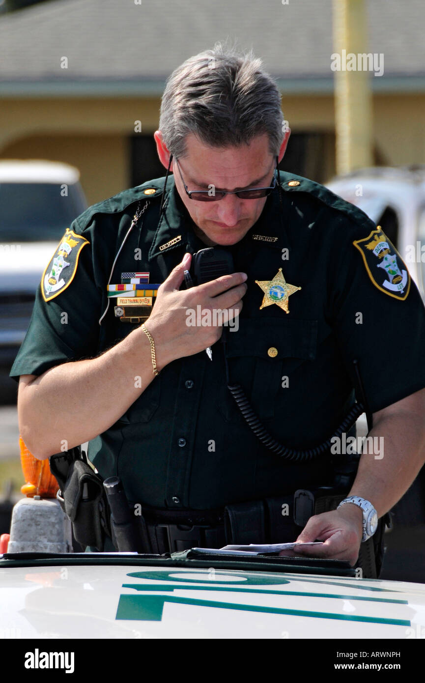 Male police officer using microphone to communicate on the scene of an ...