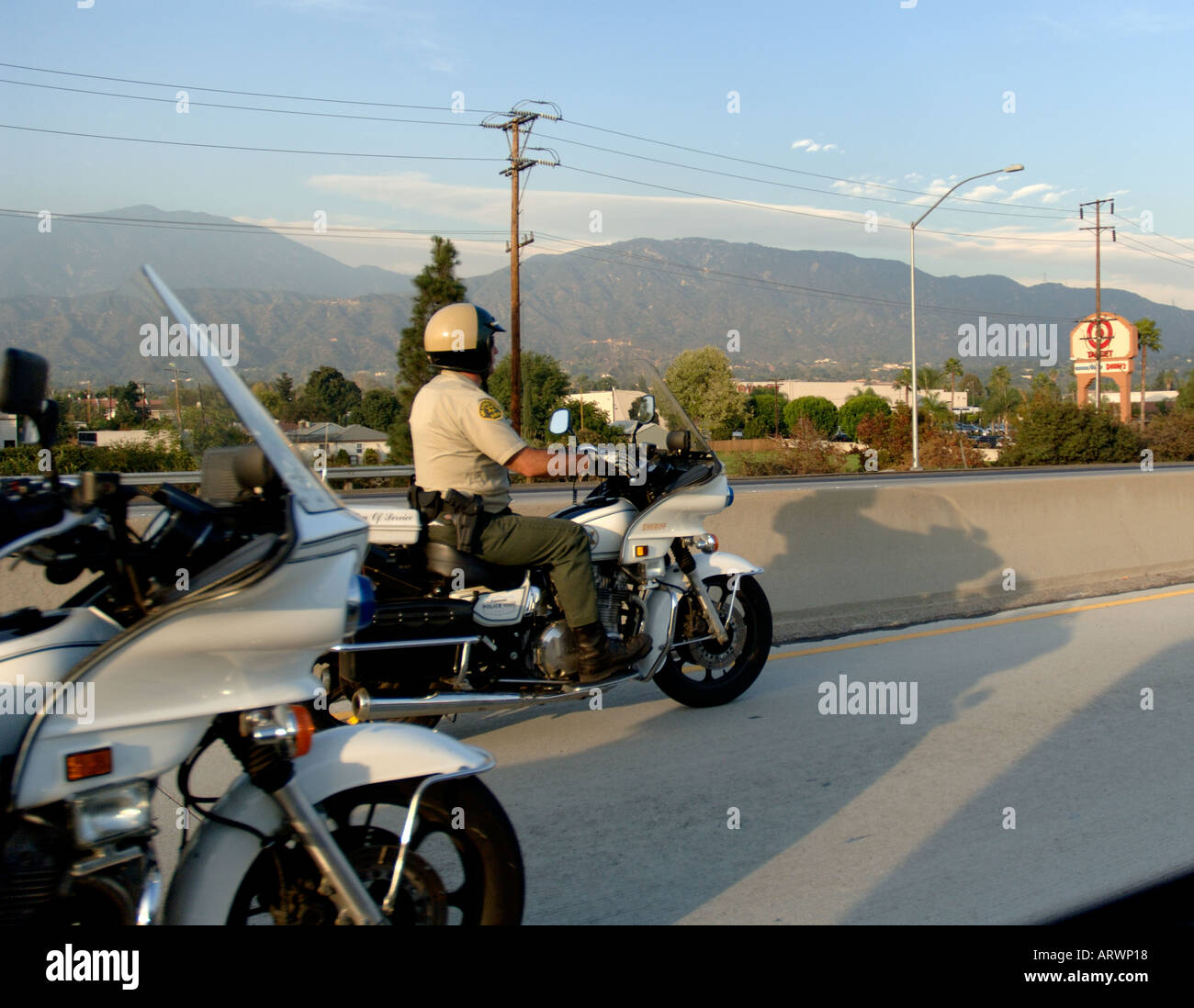 Two California Highway Patrol officers riding on the freeway side by ...
