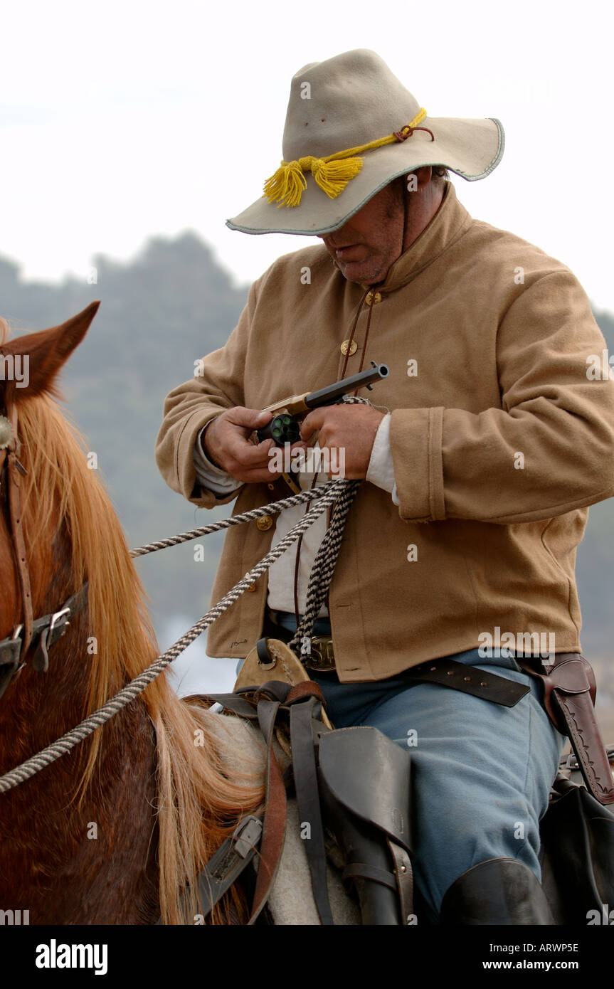 Mounted soldier loading gun preparing for Civil War reenactment event ...