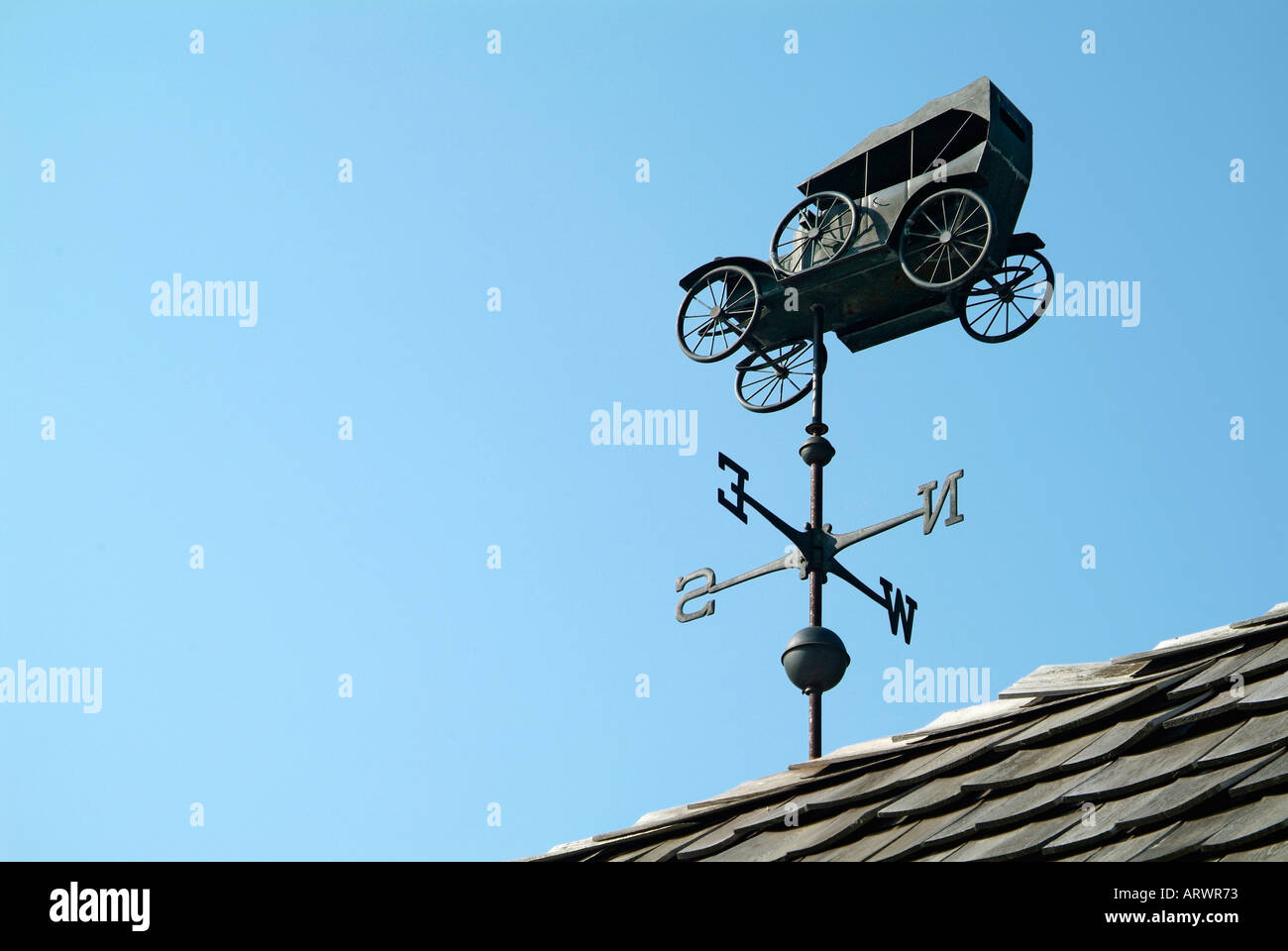 Weather vane in the shape of an antique automobile car shows the ...