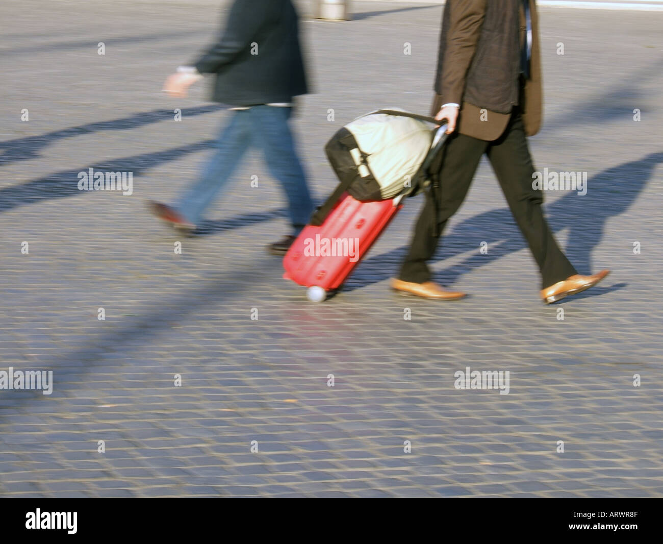 man pulling red trolley case Stock Photo - Alamy