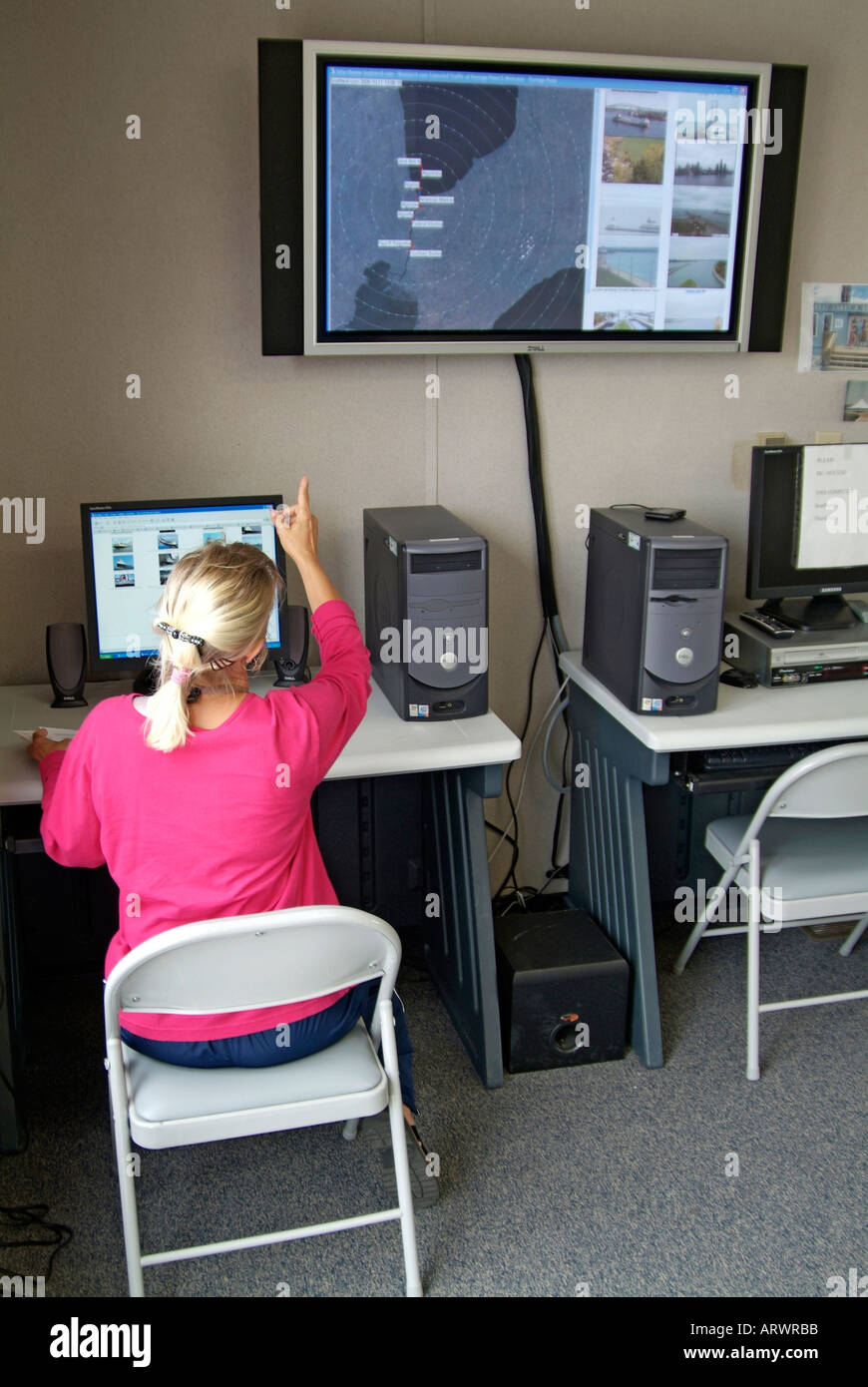 Female uses a plasma TV television as a monitor for a laptop computer ...
