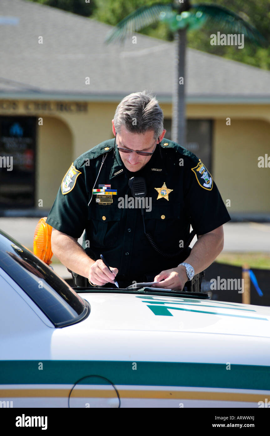 Male police officer on the scene of an accident writing a report Stock ...