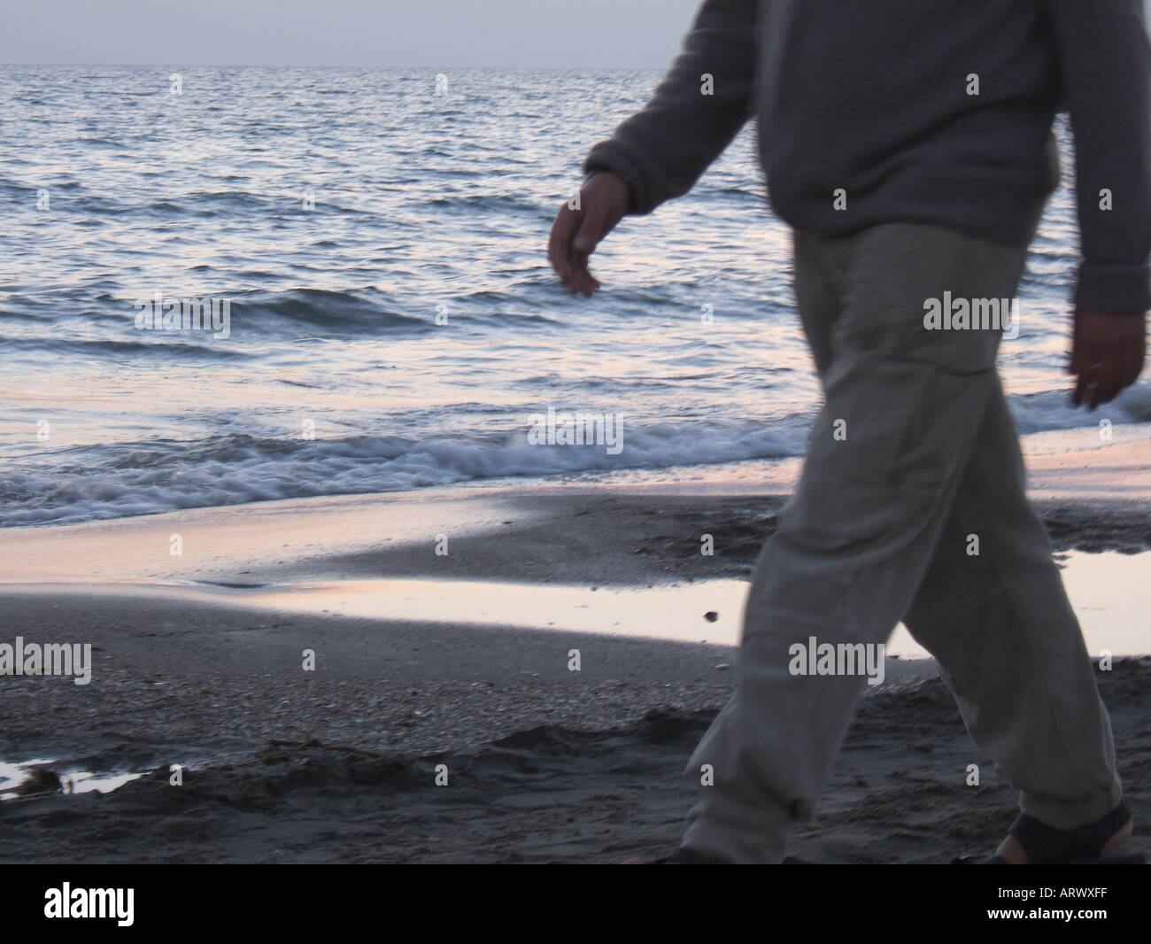 man walking along beach Stock Photo - Alamy