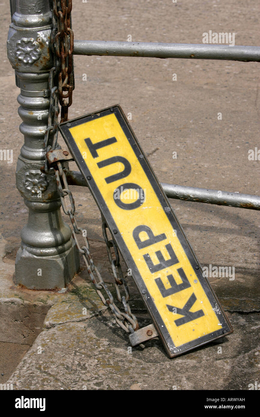 keep out danger yellow metal sign peppered bullet holes chain link wire ...