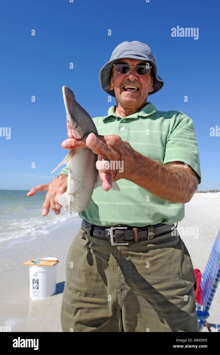 Senior man fishing for recreation in the Gulf of Mexico at Naples ...