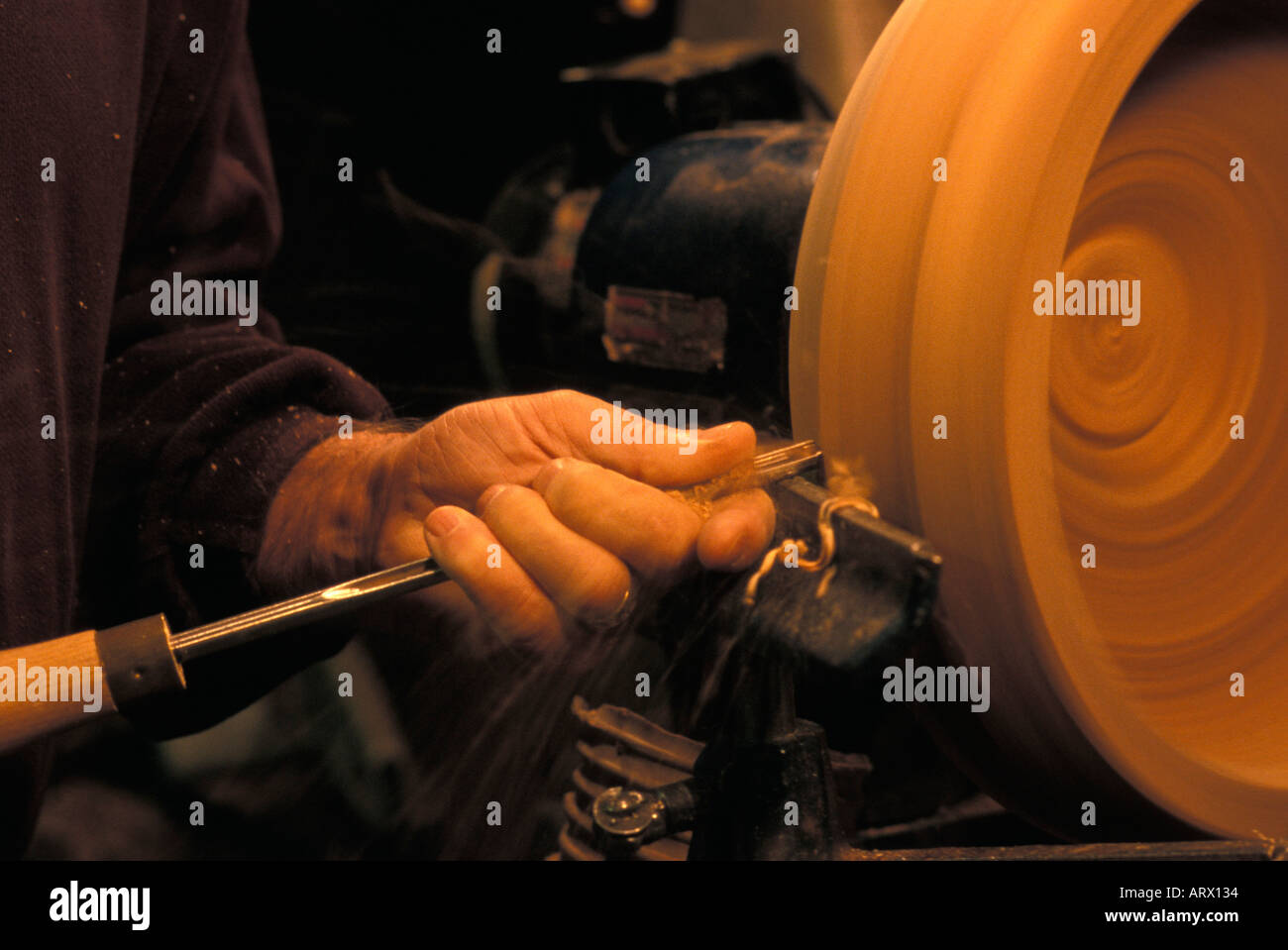 Craftsman using awl on a birds eye maple bowl that his is turing on his ...