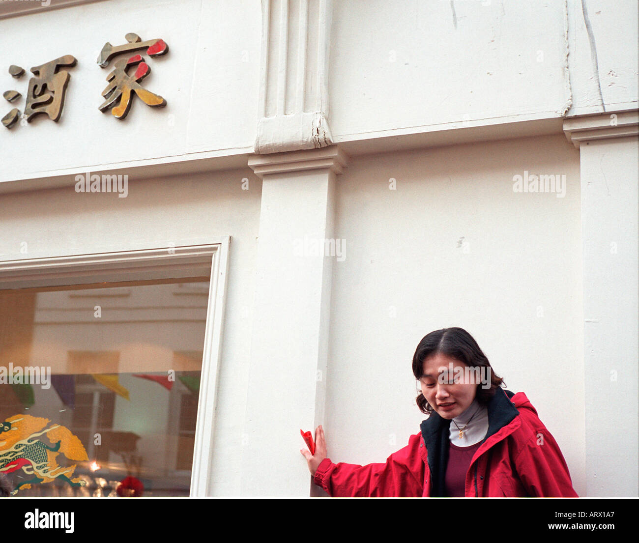 Chinese woman on ledge outside restaurant China Town London Stock Photo ...