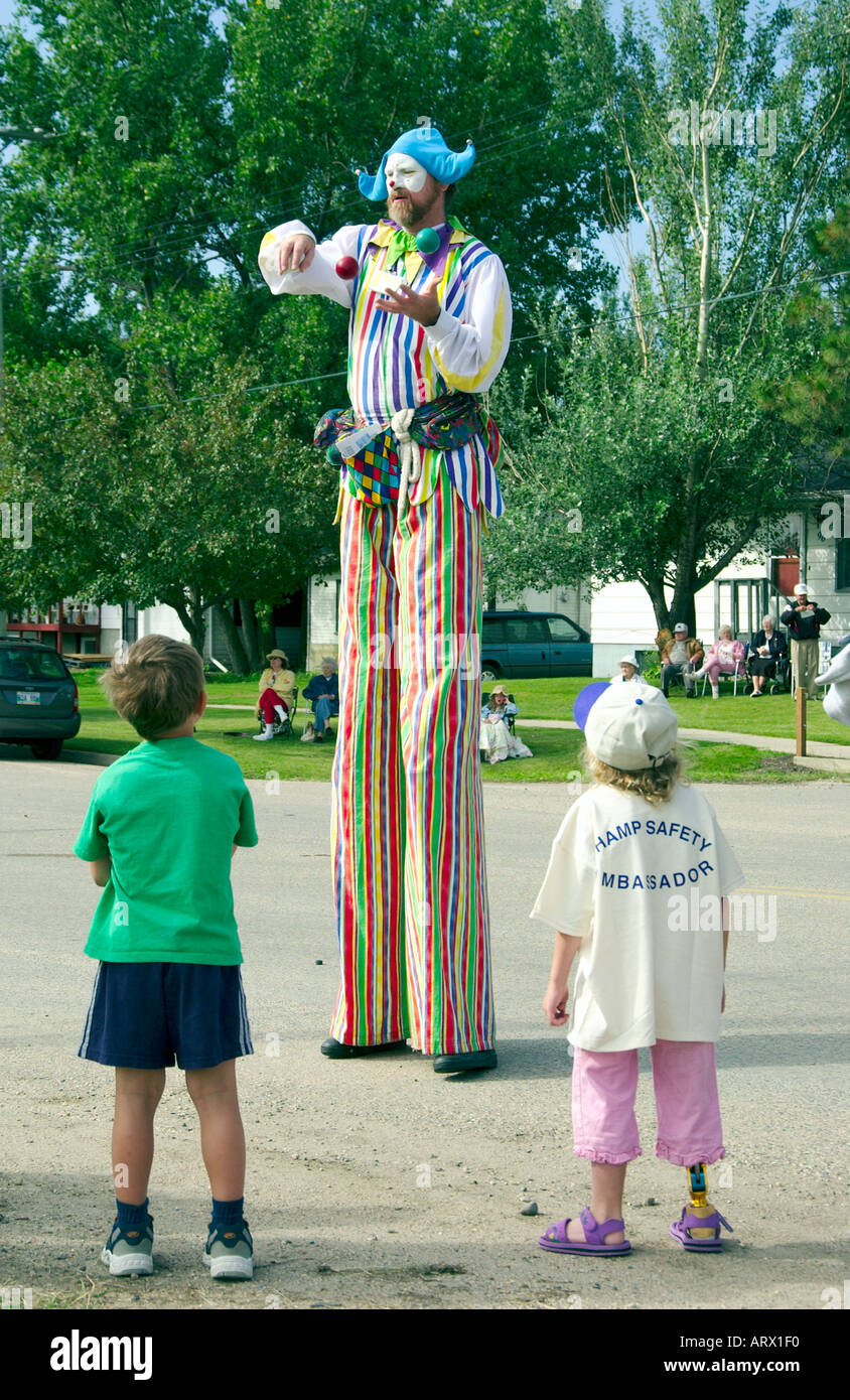 A man on stilts juggling entertaining two small children Stock Photo ...