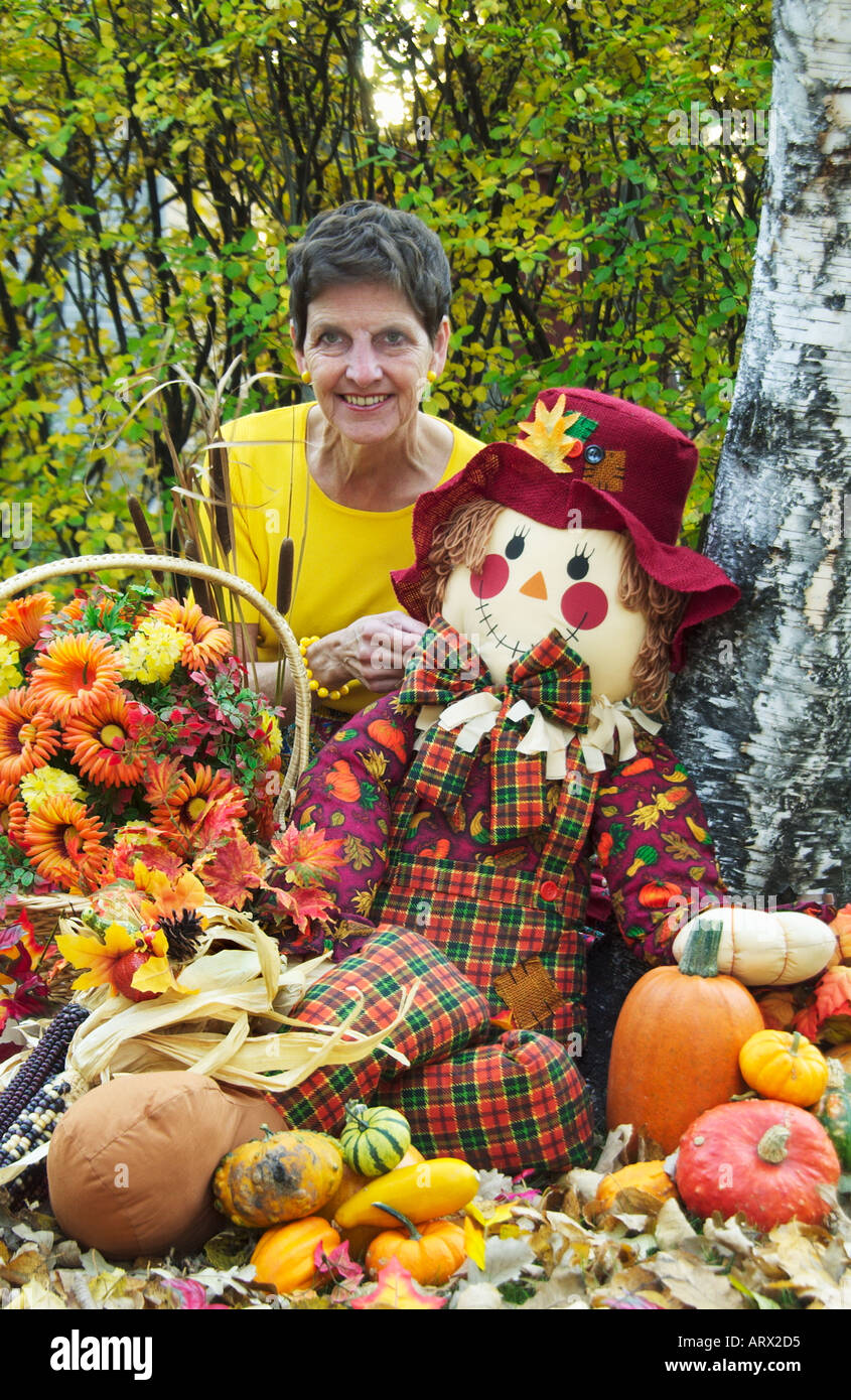 Fall display of gourds flowers and fall leaves with models in colourful ...
