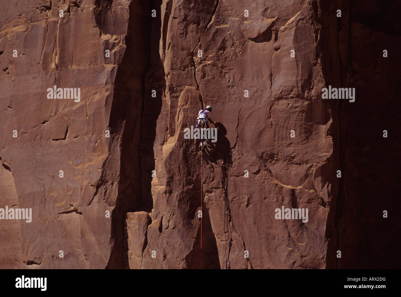 Man climbing cliff face, Arches National Park Utah Stock Photo - Alamy