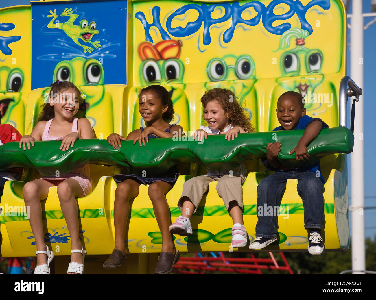 Children enjoying a ride aboard the FROG HOPPER ASTROLAND AMUSEMENT ...