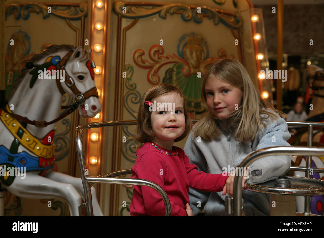 Sisters riding the carousel Stock Photo - Alamy