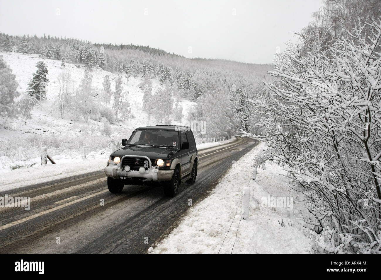 A four wheel drive 4x4 vehicle driving along a snow covered A93 road ...