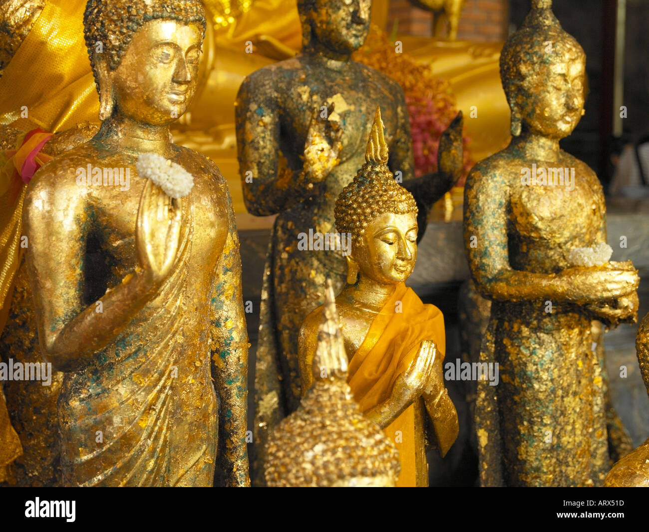 Statues of Buddhist deities covered in gold foil by devotees in the ...