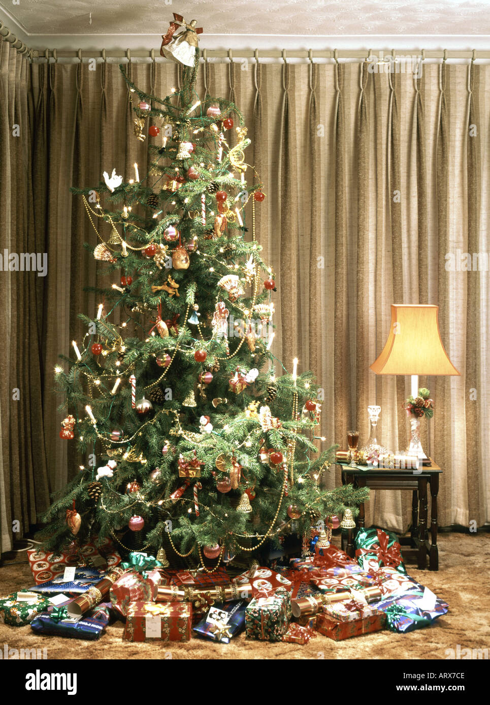 Christmas domestic lounge with presents placed below real Christmas ...