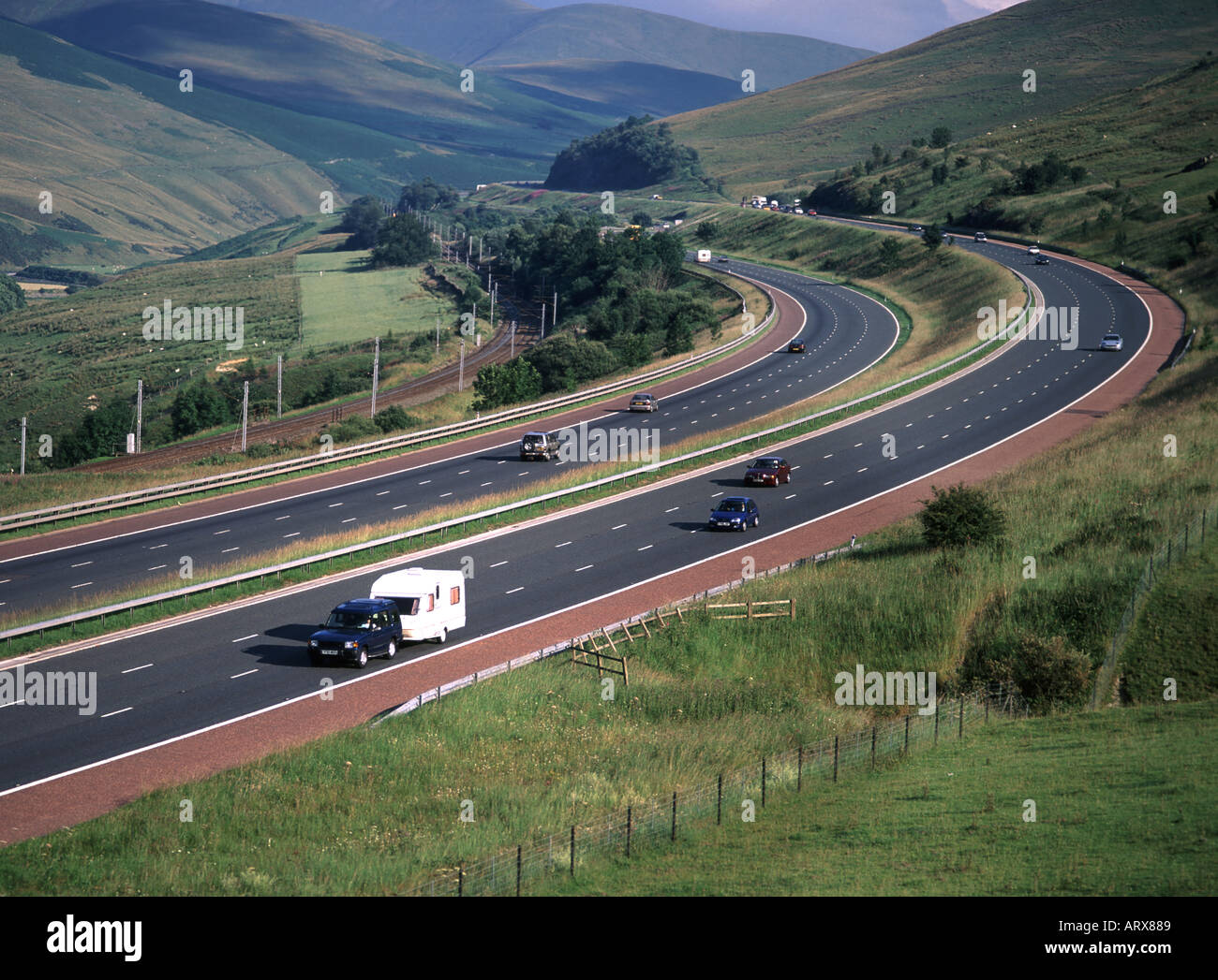 M6 motorway red tarmac hard shoulder and railway line passing through ...