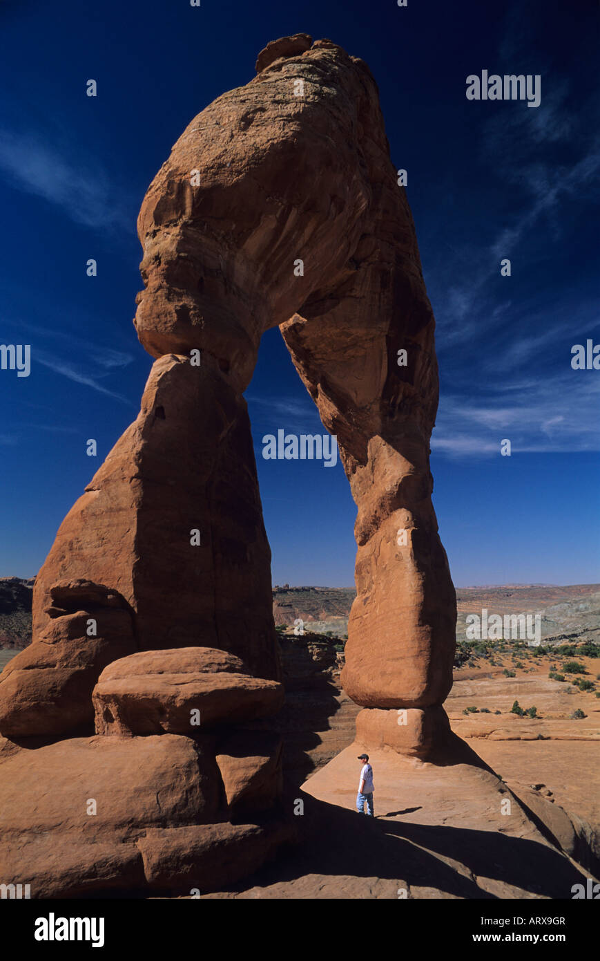 A boy stands beneath Delicate Arch Arches National Park Utah Stock ...