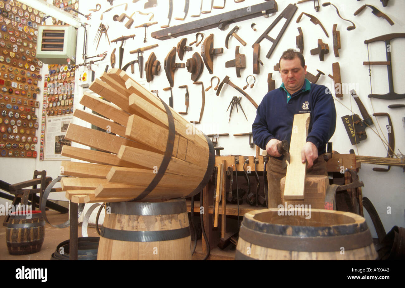 A Cooper cutting a staves with a side axe to make the side of a barrel ...