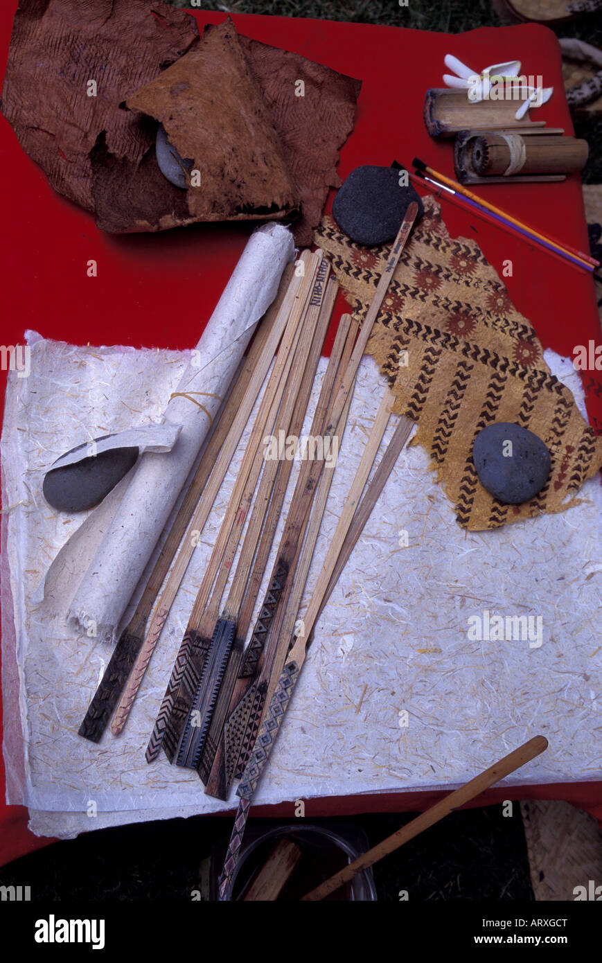 Tapa supplies, including carved wooden sticks dipped in paint and used ...
