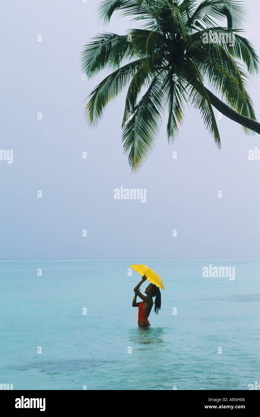 Woman standing under palm trees hi-res stock photography and images - Alamy