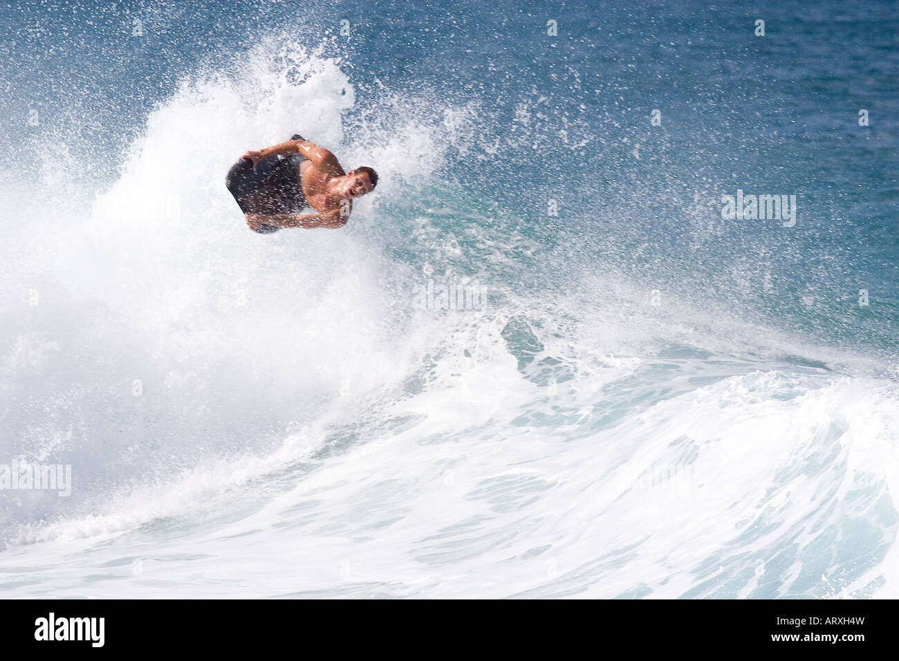 Man catching air on a bodyboard at rock piles surf break Stock Photo ...