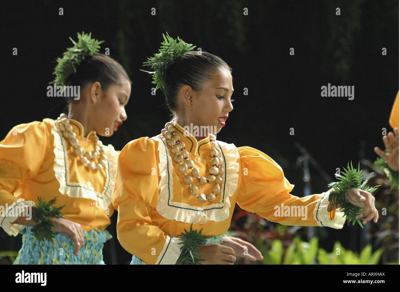 Two girls in dancing hula. Profile view Stock Photo - Alamy