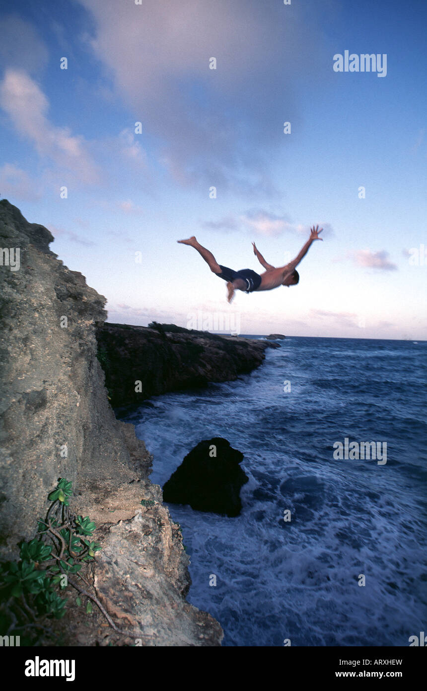 Young man cliff diving of Laie point at sunset Stock Photo - Alamy