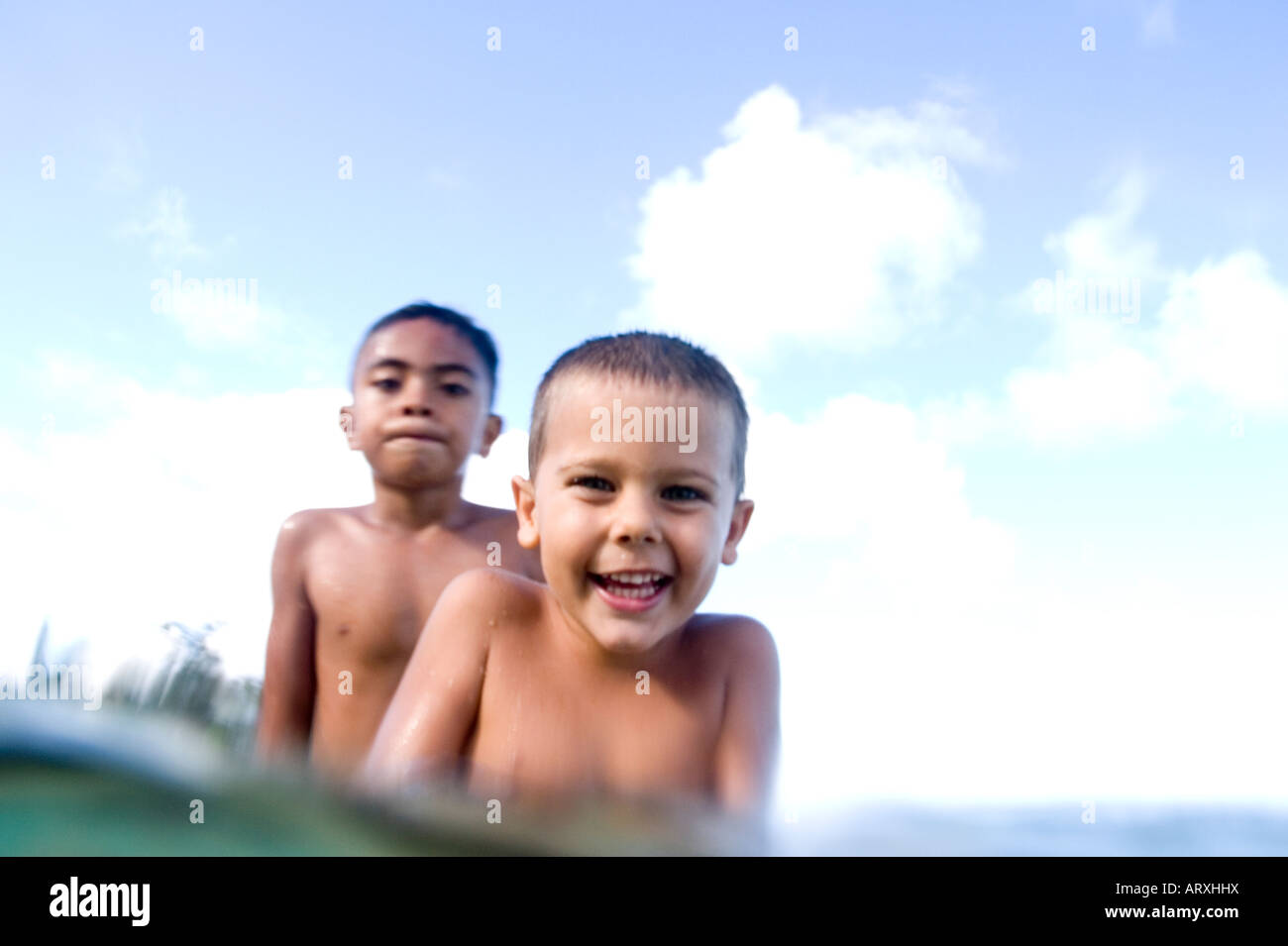 Two boys playing in the water. Over under water shot. Multicultural ...