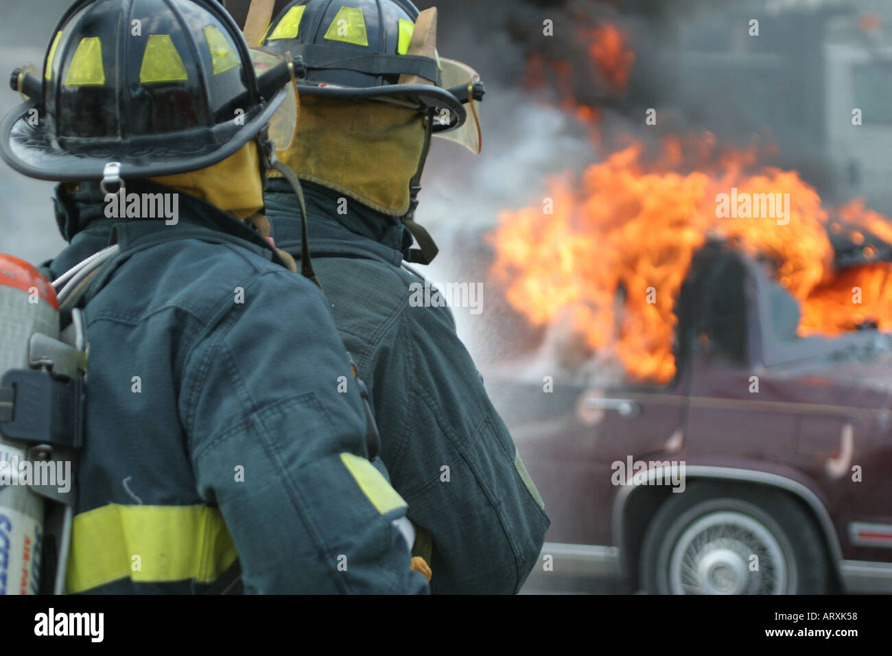 Two fire fighters are putting out a car fire Stock Photo - Alamy