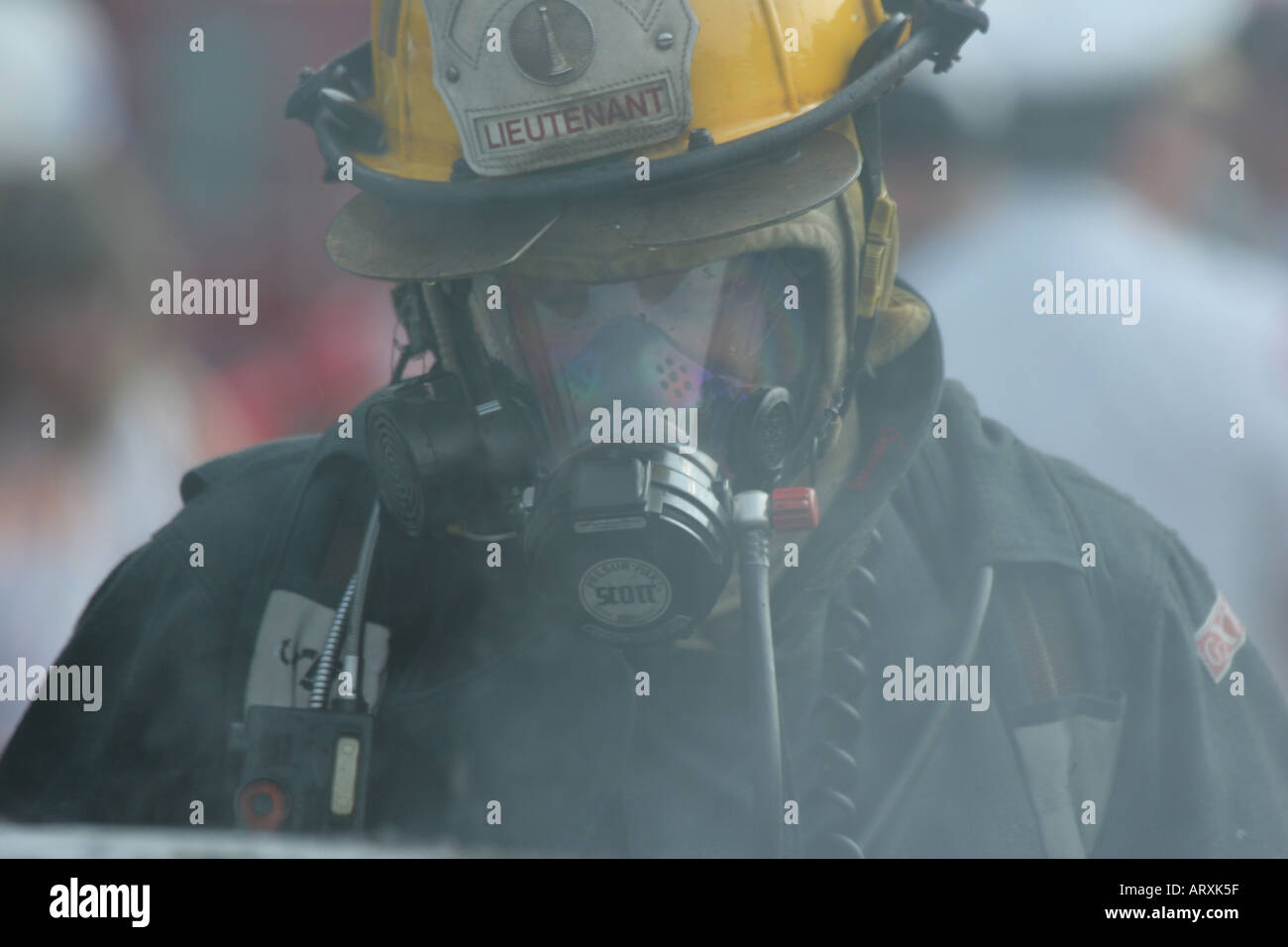 Fire fighter in a smoke haze looking down on a car fire Stock Photo - Alamy