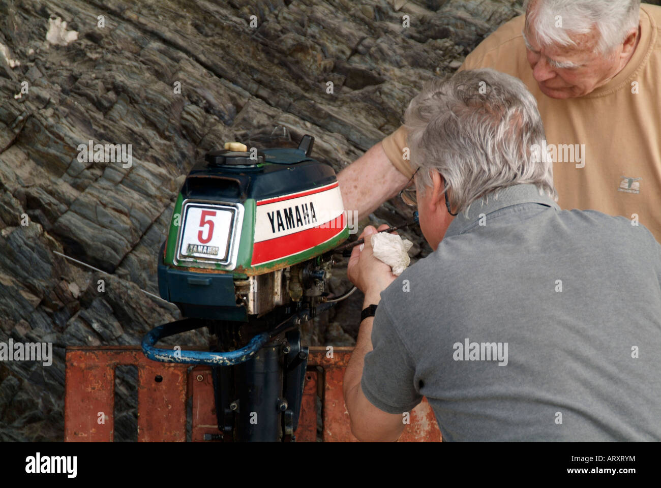 men repairing outboard motor Stock Photo - Alamy