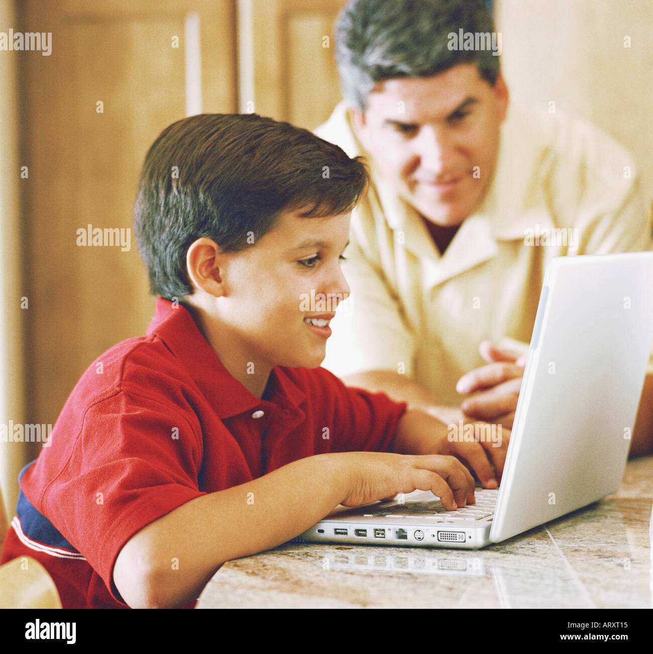 Young Hispanic Boy with Father Doing Homework in Kitchen of New Home ...