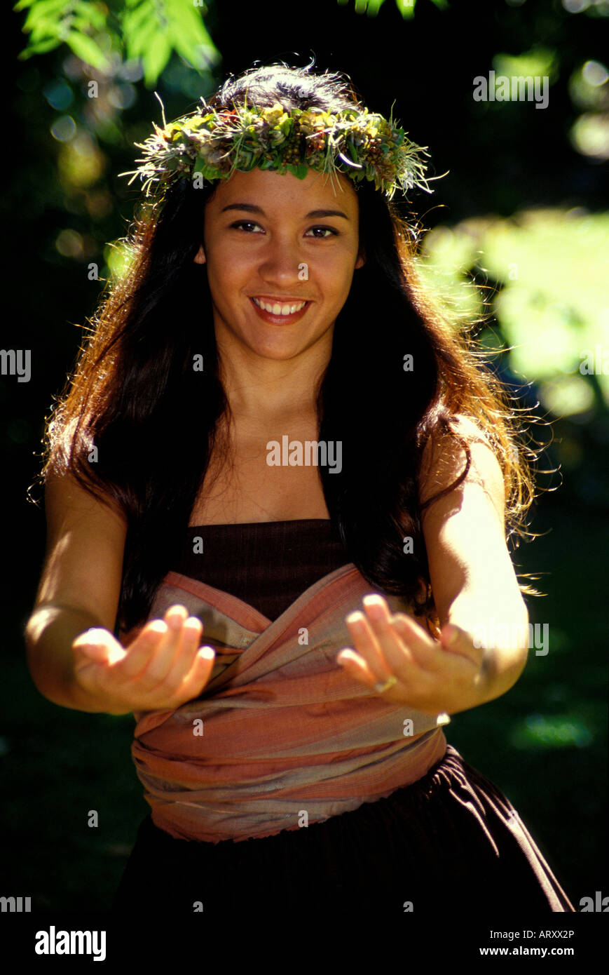 Smiling Hawaiian hula dancer in a park in Honolulu on Oahu, dancing ...