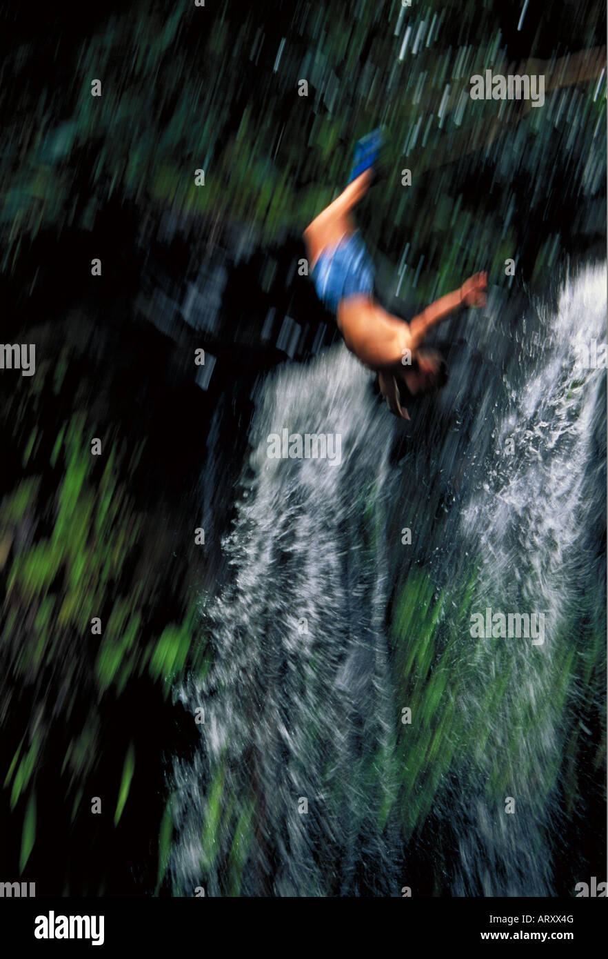 Diving off cliff with waterfall Stock Photo - Alamy