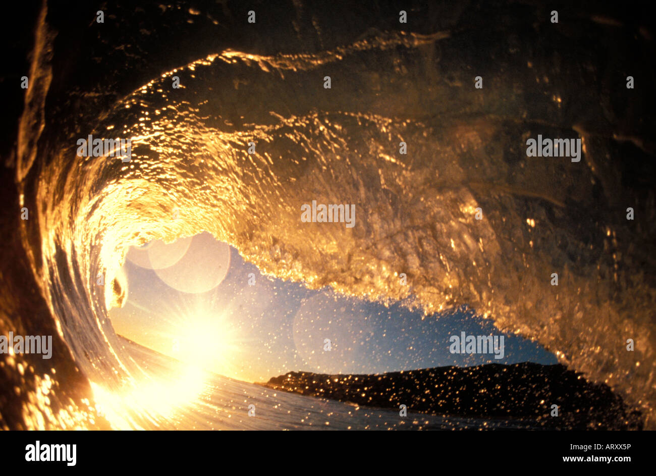 View of the sunset through the tunnel of North Shore waves, Oahu Stock ...