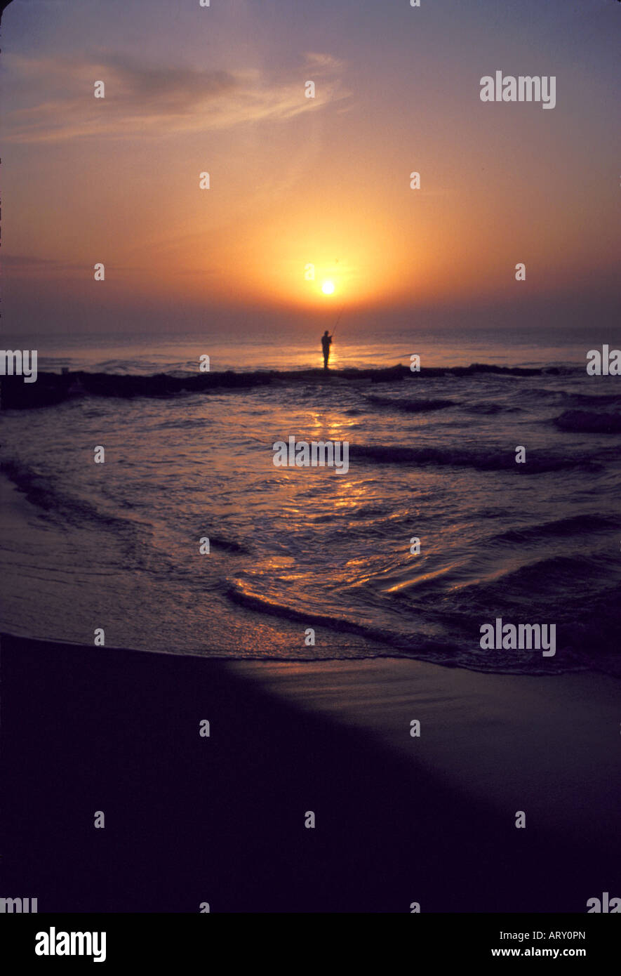 Man shoreline fishing at sunset, island of Kauai Stock Photo - Alamy