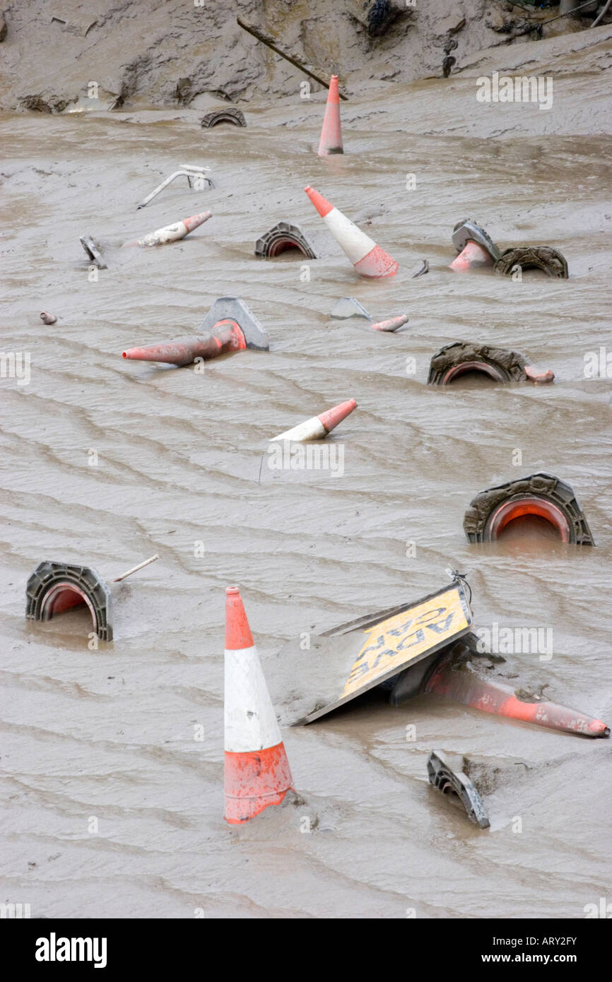 Plastic traffic cones and road signs thrown into the silt and mud of ...
