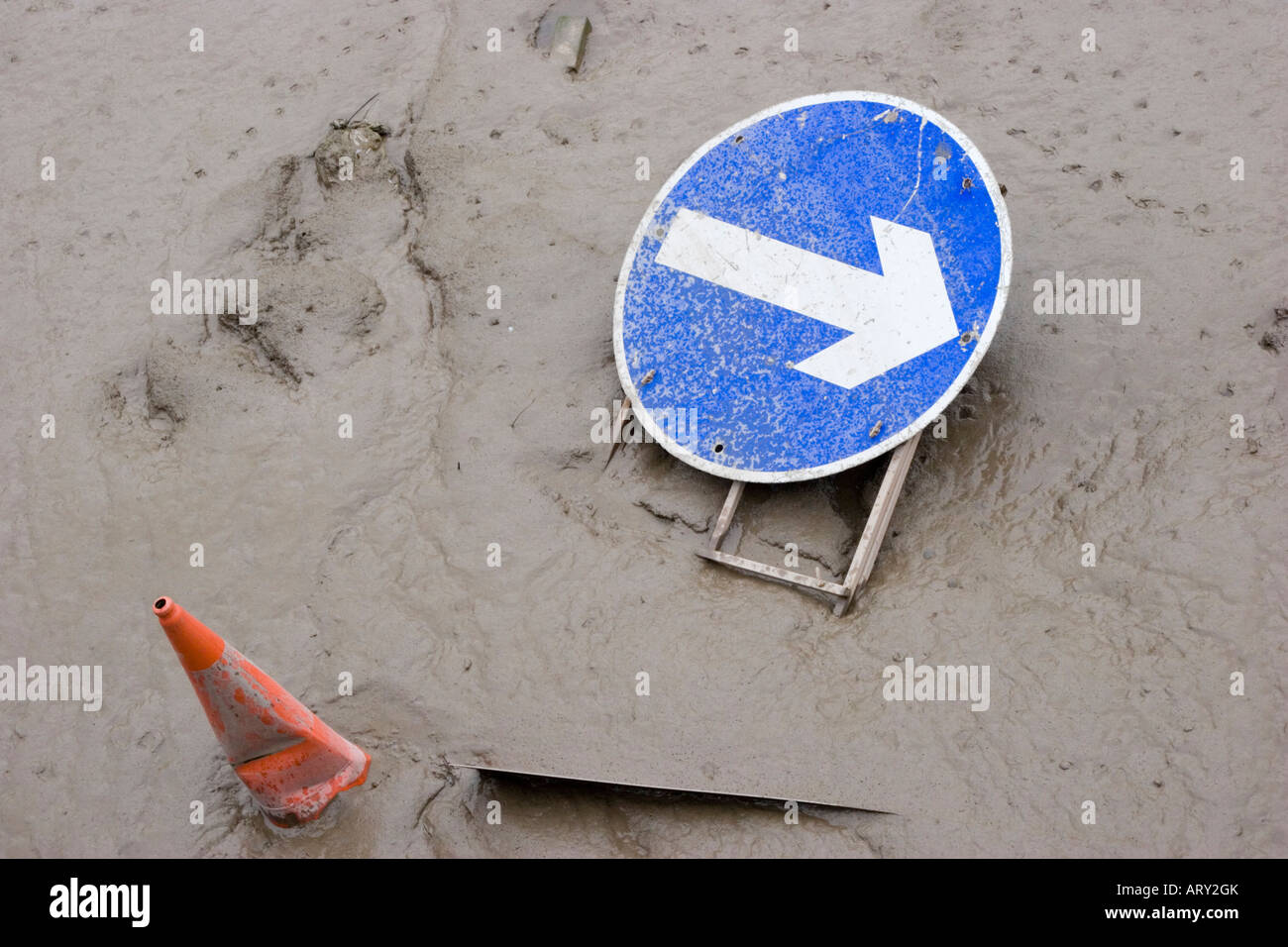 Plastic traffic cones and road signs thrown into the silt and mud of ...