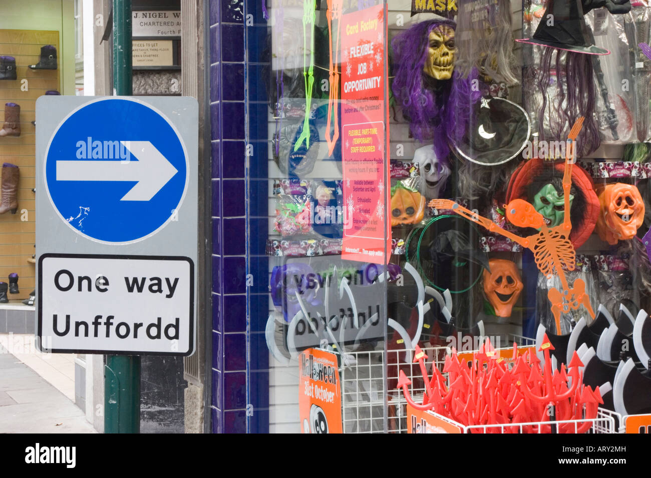 Dual language one way road sign next to a halloween shop window Stock ...