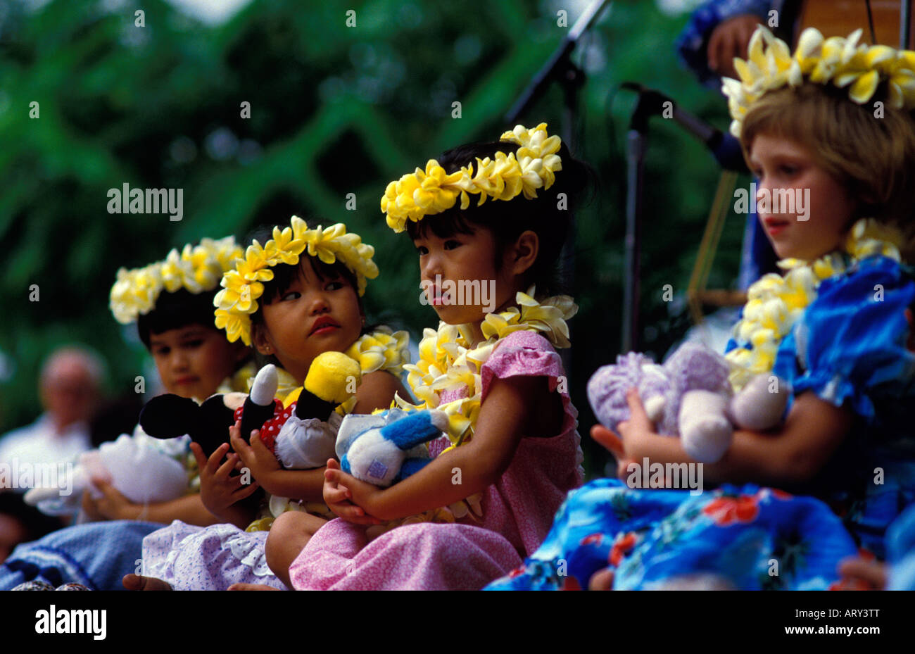 Four young island keiki hula dancers performing a noho (seated) hula ...