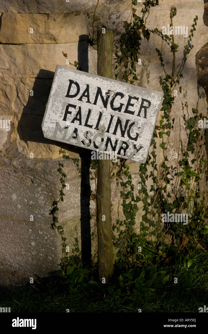 Lop-sided sign warning of: Danger, falling masonry Stock Photo - Alamy