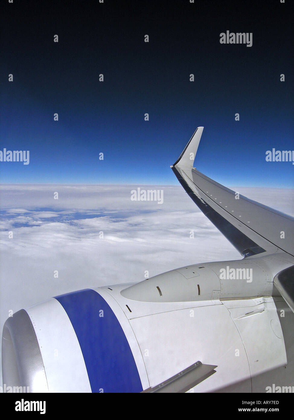 View from aircraft window to engine and wing of aircraft flying above ...