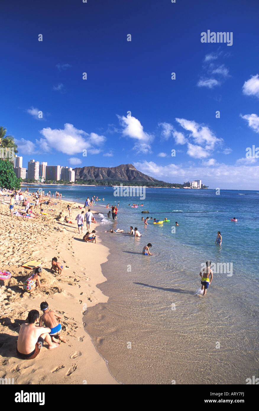 Vacationers from around the world enjoy the sands of Waikiki beach with ...
