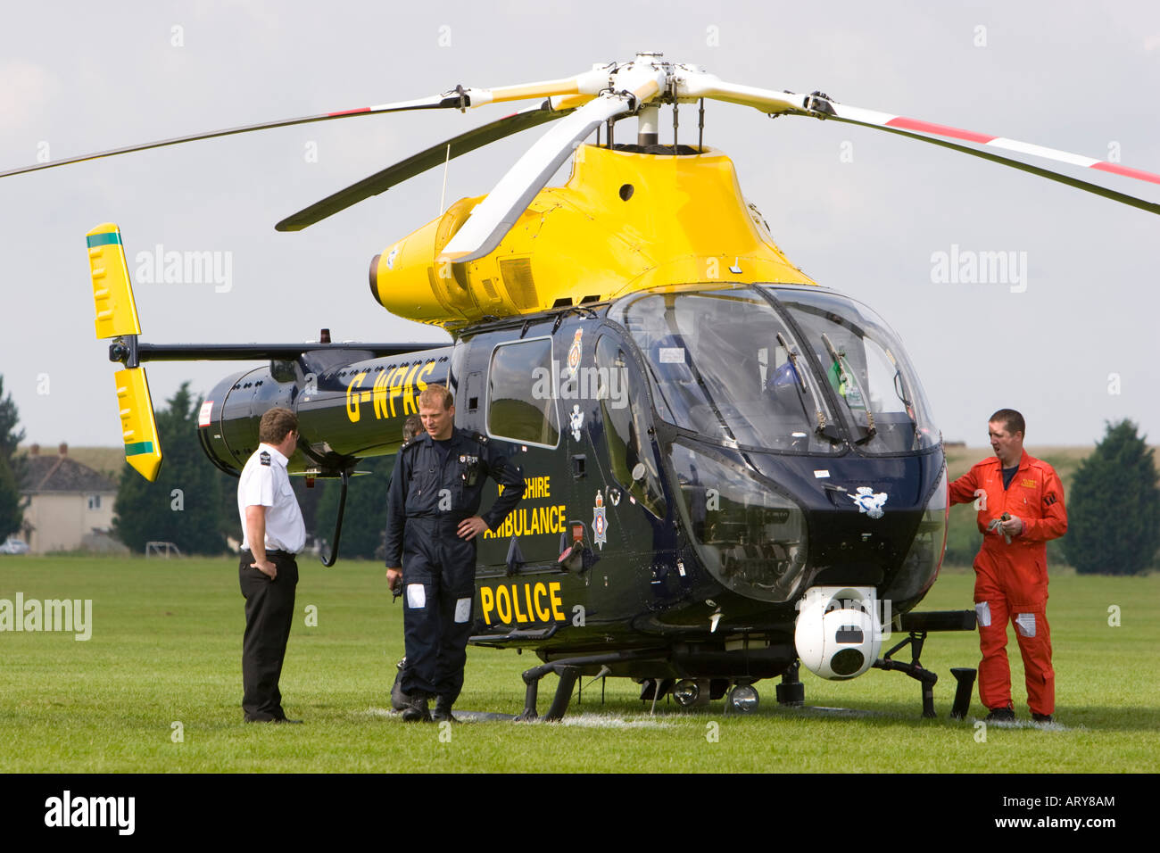 Police helicopter and air ambulance on the ground with pilot and crew ...