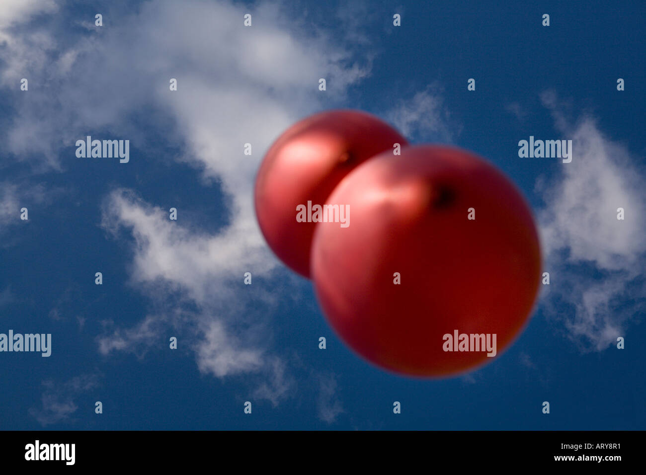 Two balloons floating off into a bright blue sky with clouds Stock ...