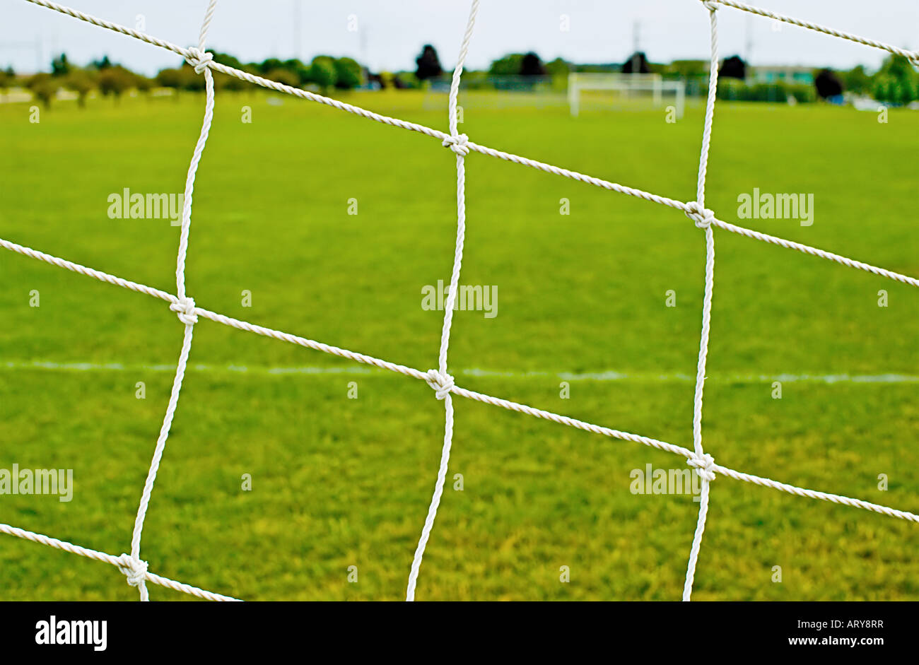 Soccer field view through net Stock Photo - Alamy