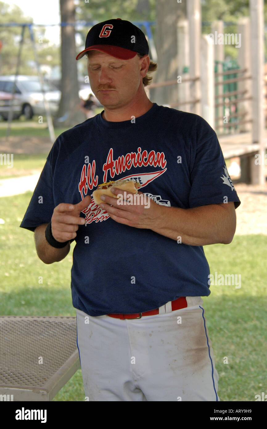 Baseball player Taking five to eat a hotdog Stock Photo - Alamy