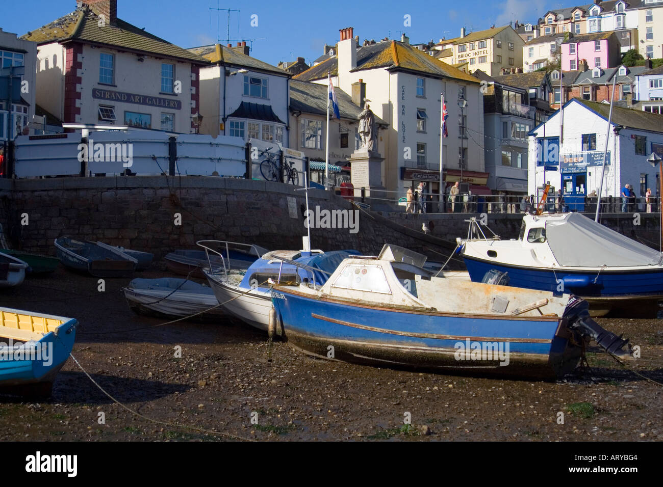 Small boats left high and dry by the retreating tide in Brixham Harbour ...