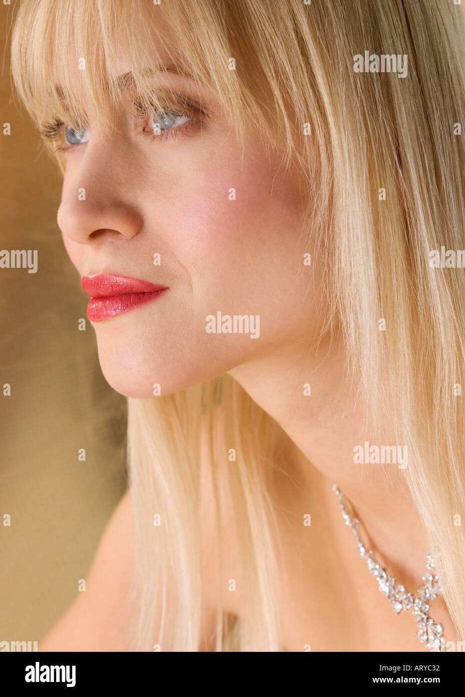 Profile of blond woman wearing necklace Stock Photo - Alamy